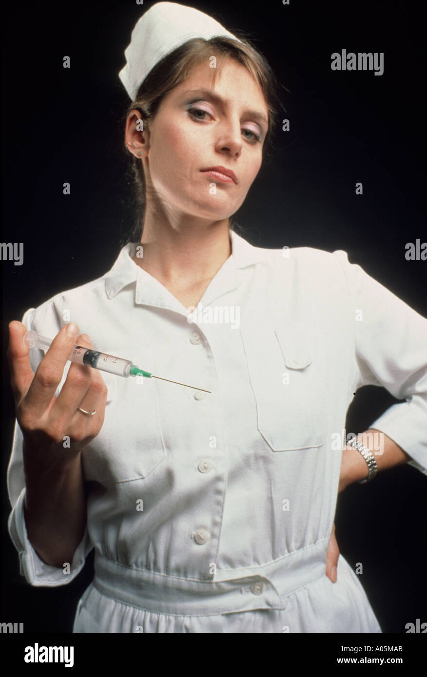 Portrait of a female nurse holding a hypodermic needle in her hand ...