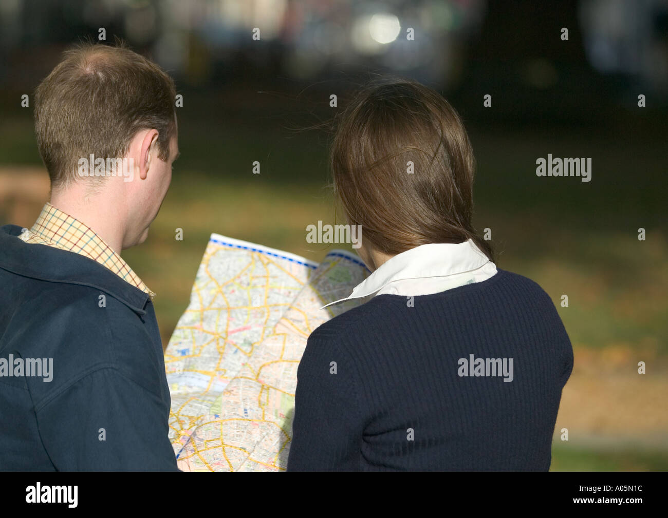 boy and girl backs turned looking at map for directions Stock Photo - Alamy