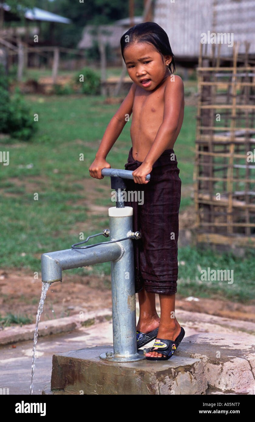 Young girl pumping water with a pump provided by an aid organization ...