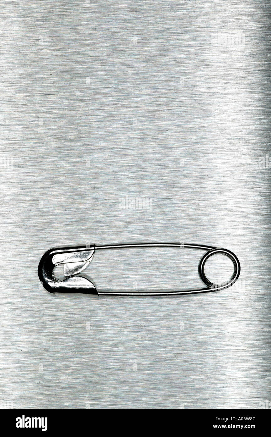 Safety pin on a stailess steel background ring flash Stock Photo - Alamy