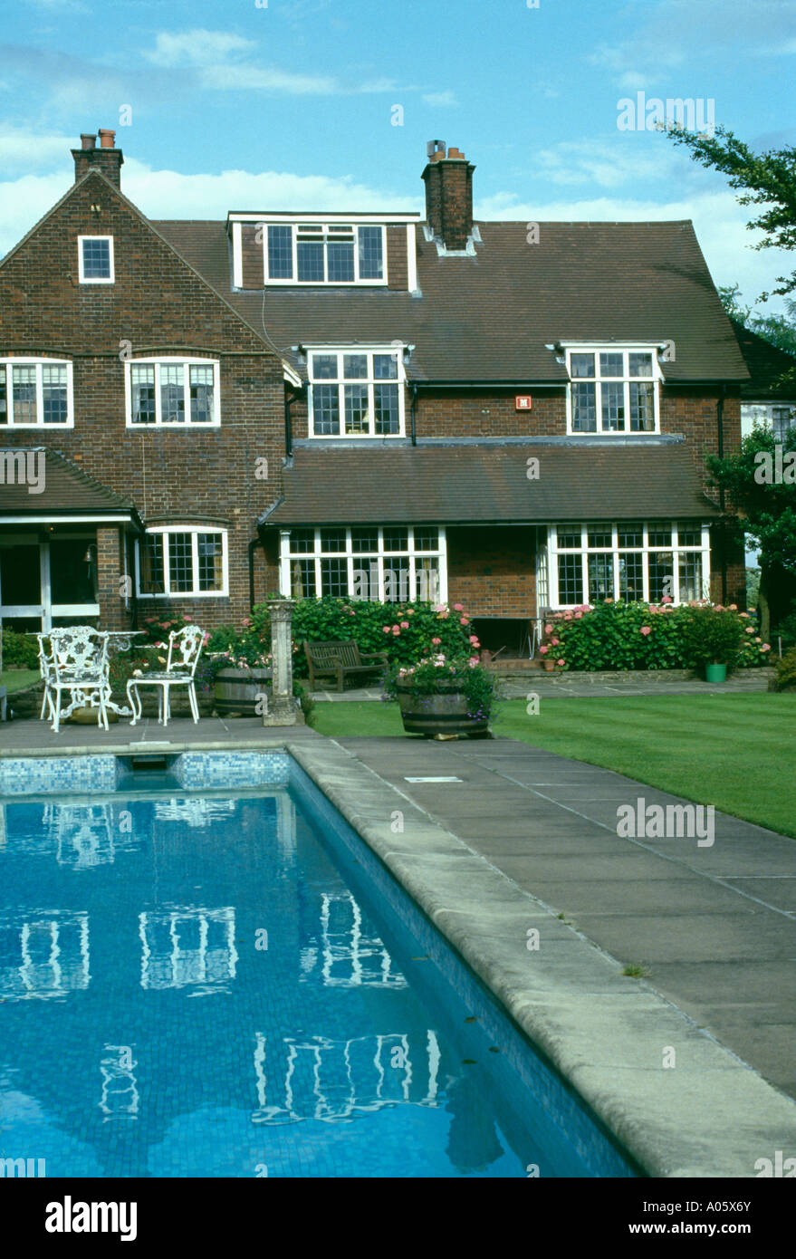 Swimming pool in front of large country house Stock Photo - Alamy