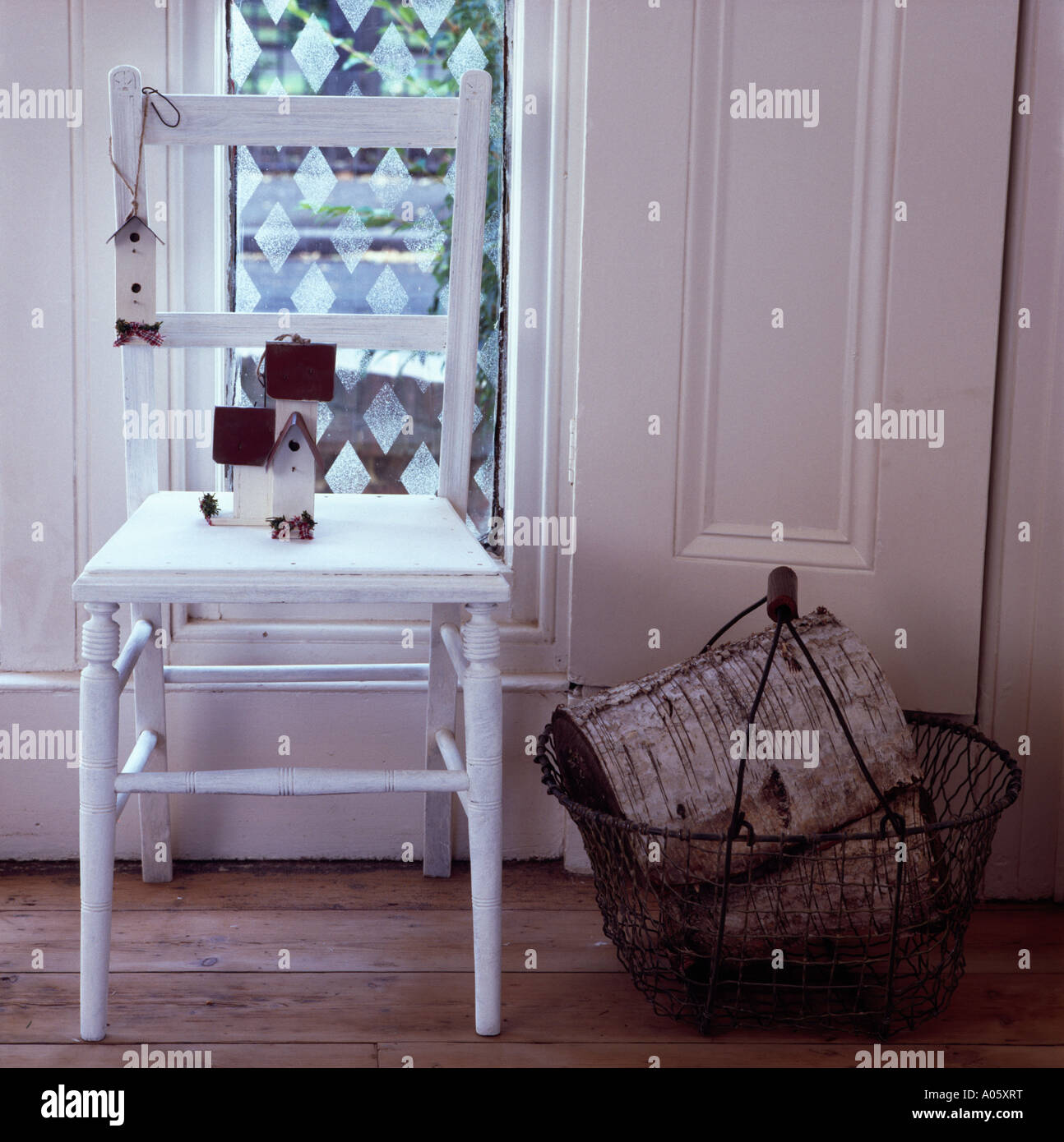 Close-up of miniature rustic wooden houses on white wooden chair beside ...