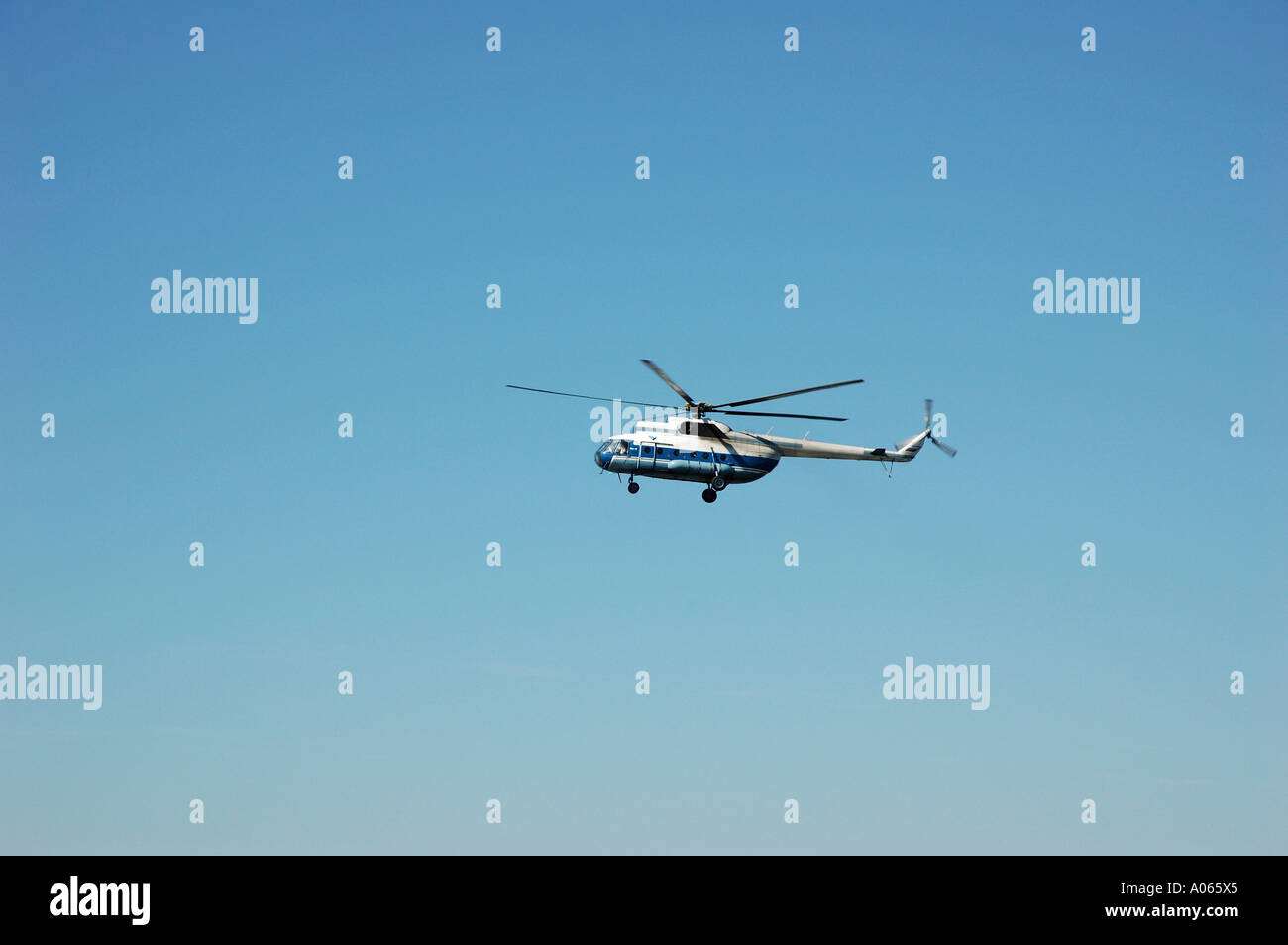 A helicopter with large overhead blades is seen in air under the sky ...