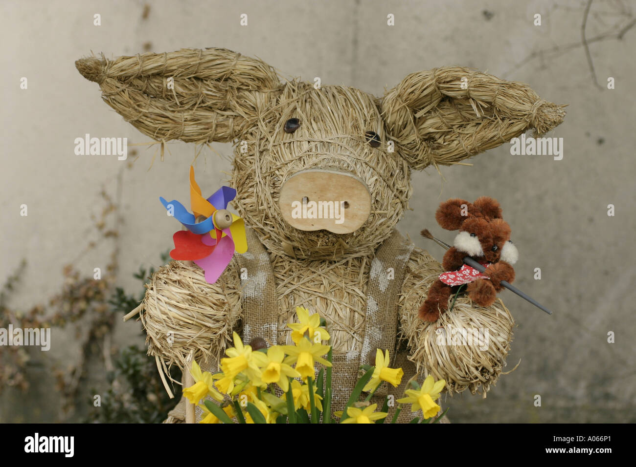 Straw made pig is seen with a stuffed toy and yellow flowers Stock ...