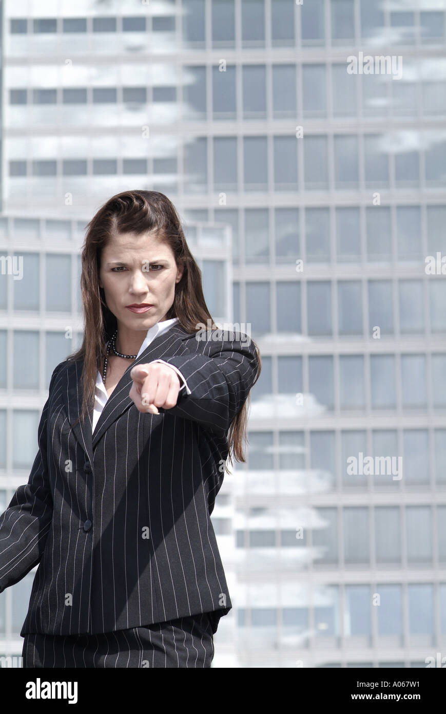 A woman pointing towards the camera as a building is seen at the ...