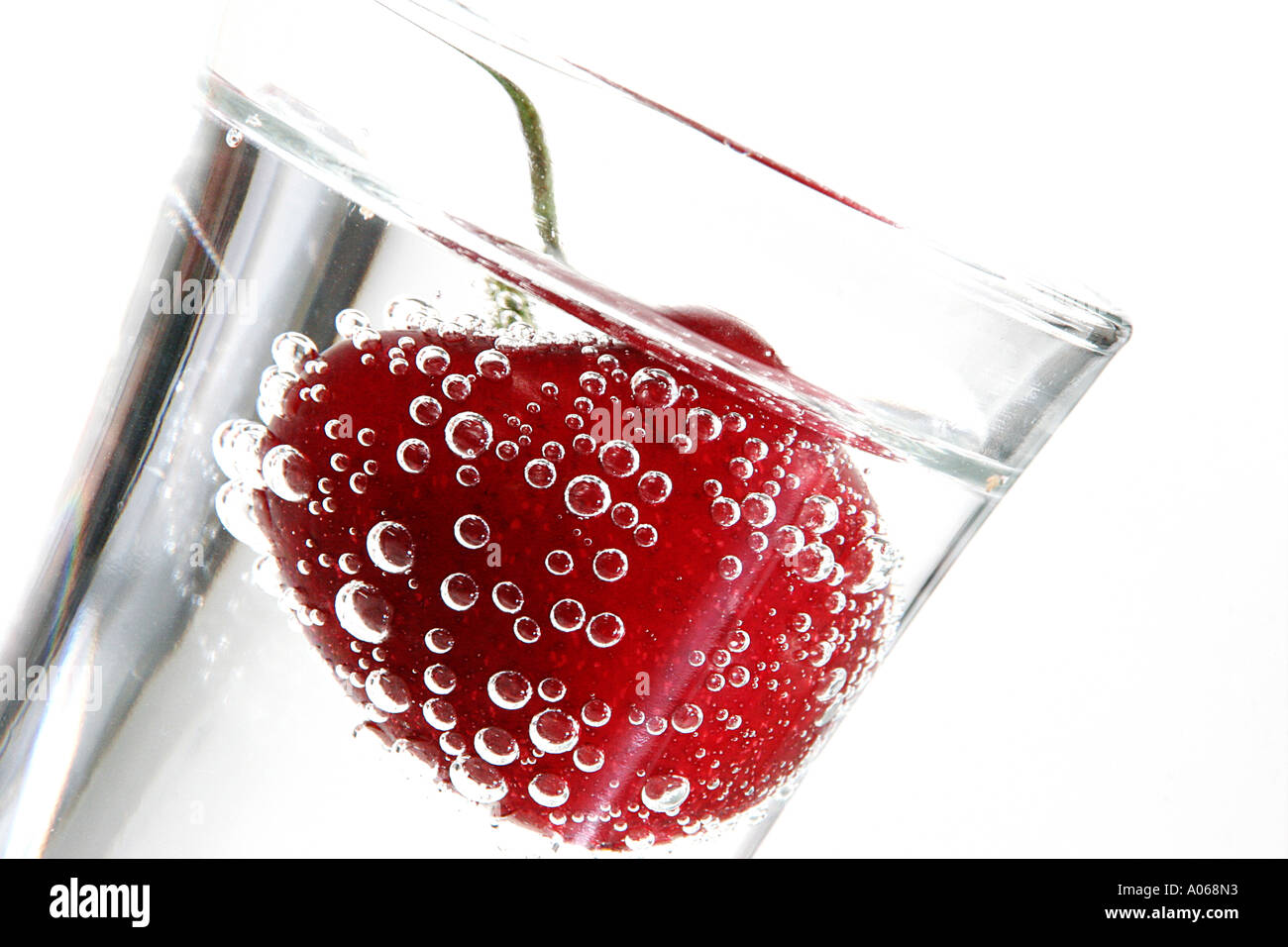A cherry being immersed in a glass of water Stock Photo - Alamy