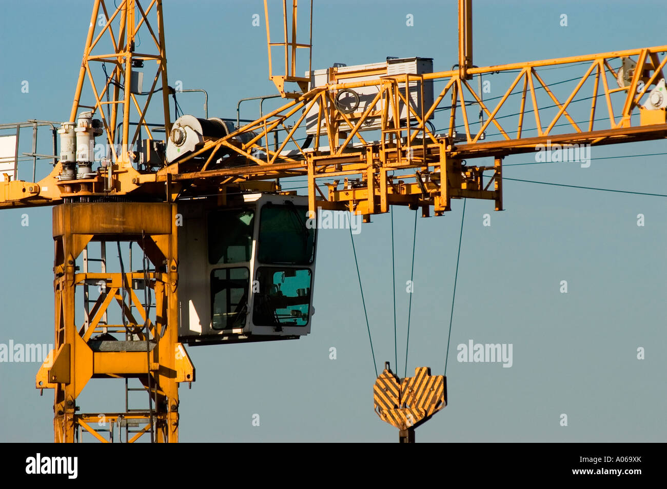 Close up of part of construction crane with operator cabin and blue sky ...