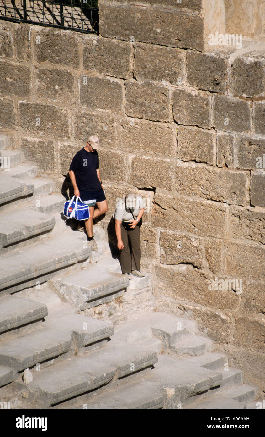 Tourist climbing down the stone steps of the ancient amphitheatre said ...