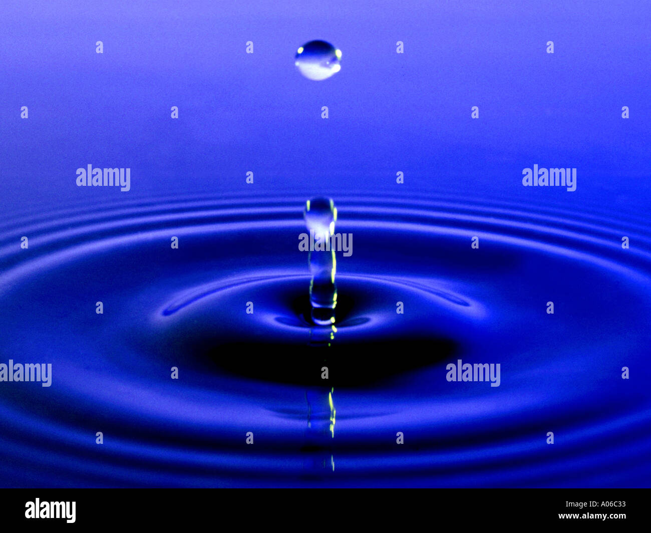 water droplet falling into blue liquid Stock Photo - Alamy