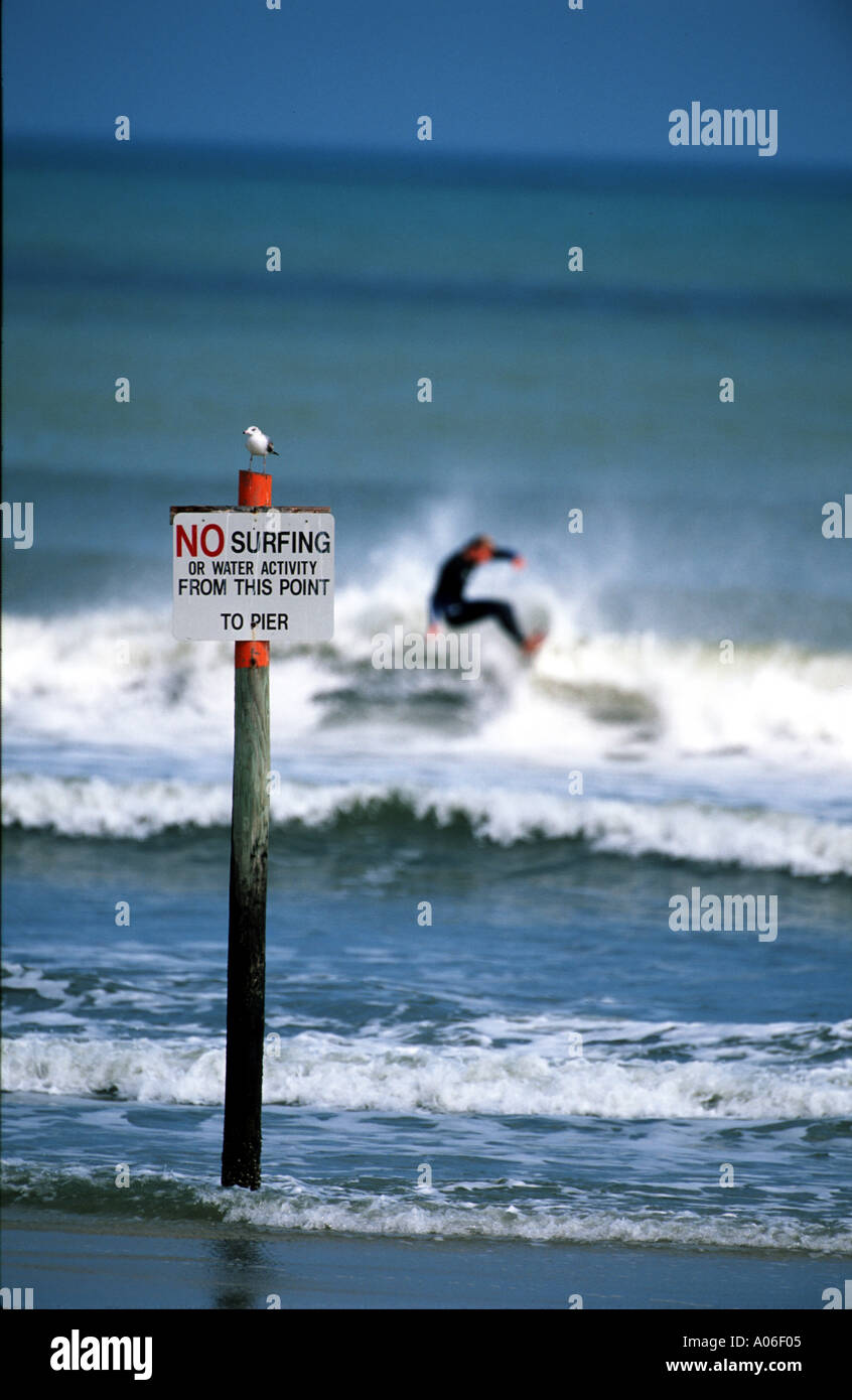 surfing in dangerous waters behind sign warning : "No surfing or water ...