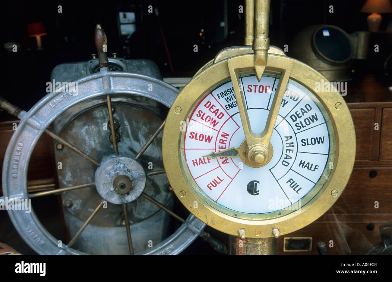 Detail of brass Engine Telegraph and a ship steering wheel in an ...