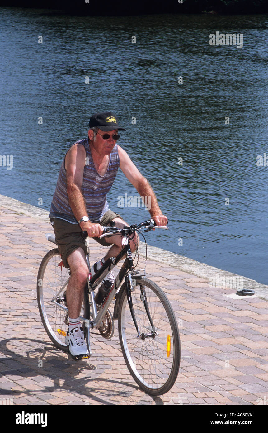 Man riding cycle along river side in Brittany Stock Photo - Alamy
