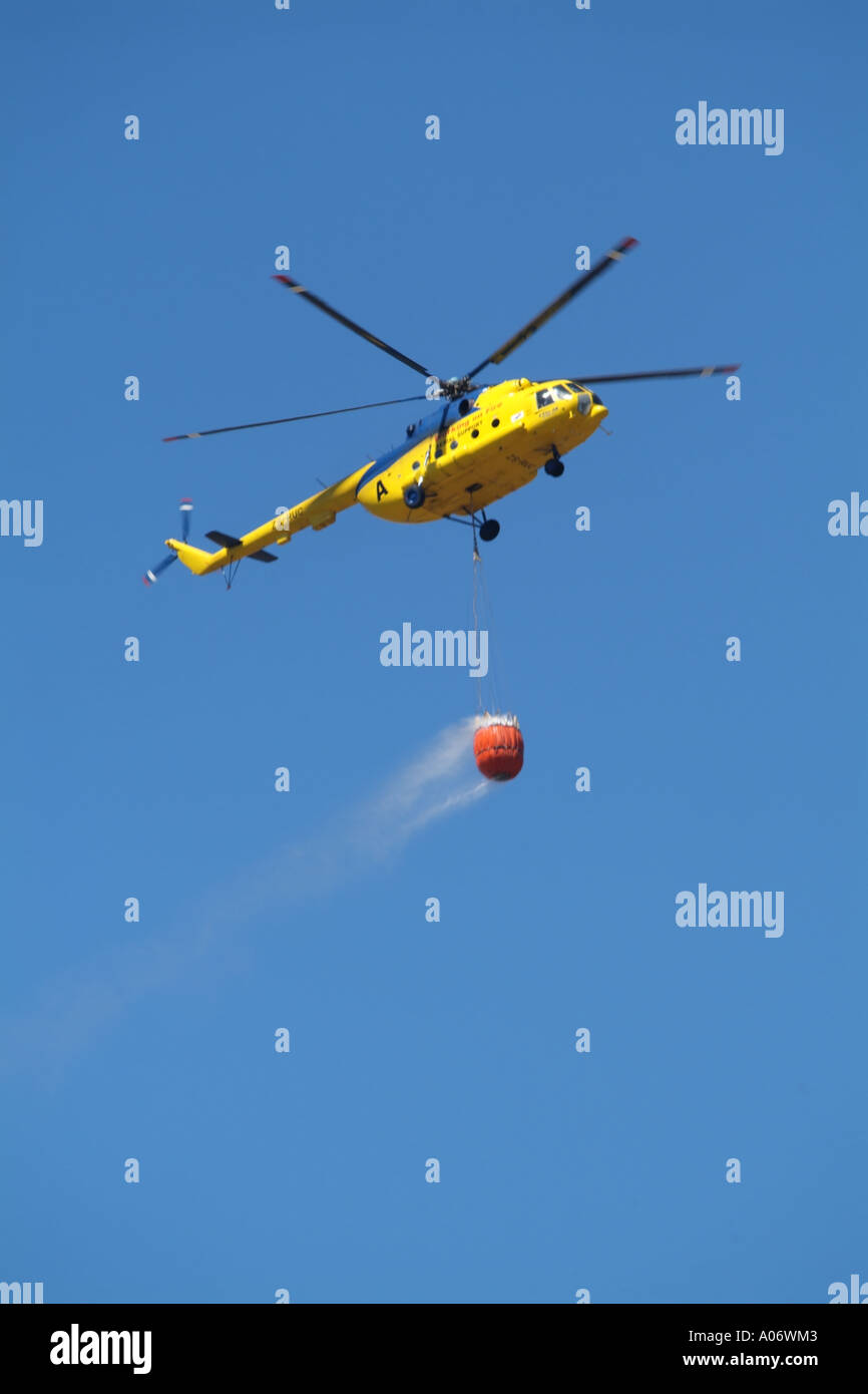 Fire service helicopter carrying bucket of water near Cape Town South ...