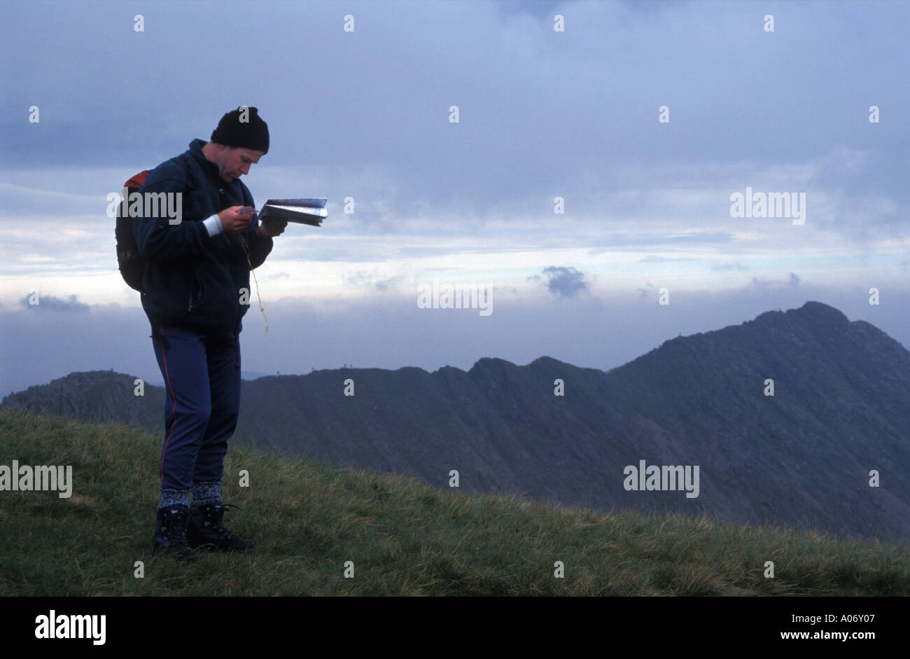 Man reading map in the high hills to check his route Stock Photo - Alamy