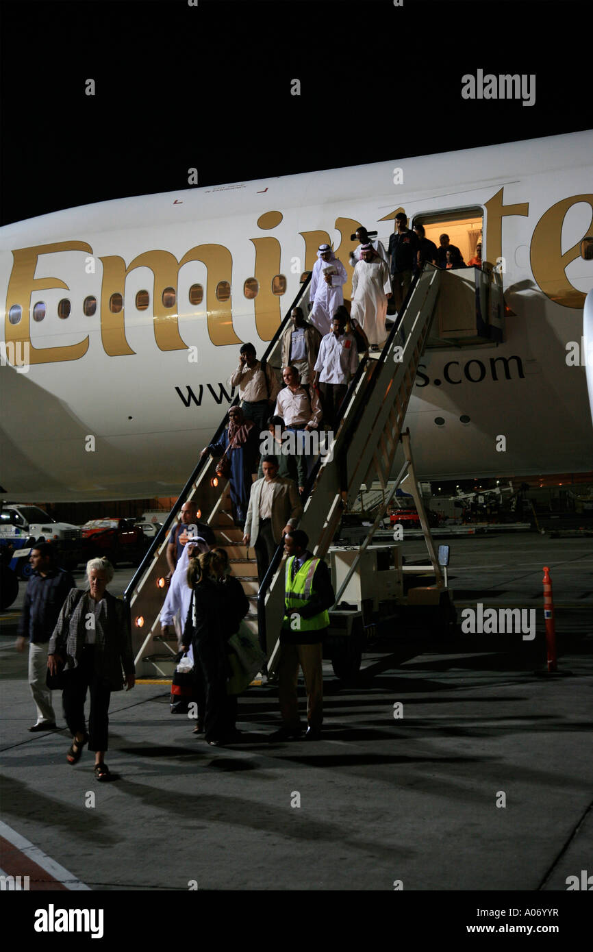 Emirates plane with passengers disembarking at night at dubai ...