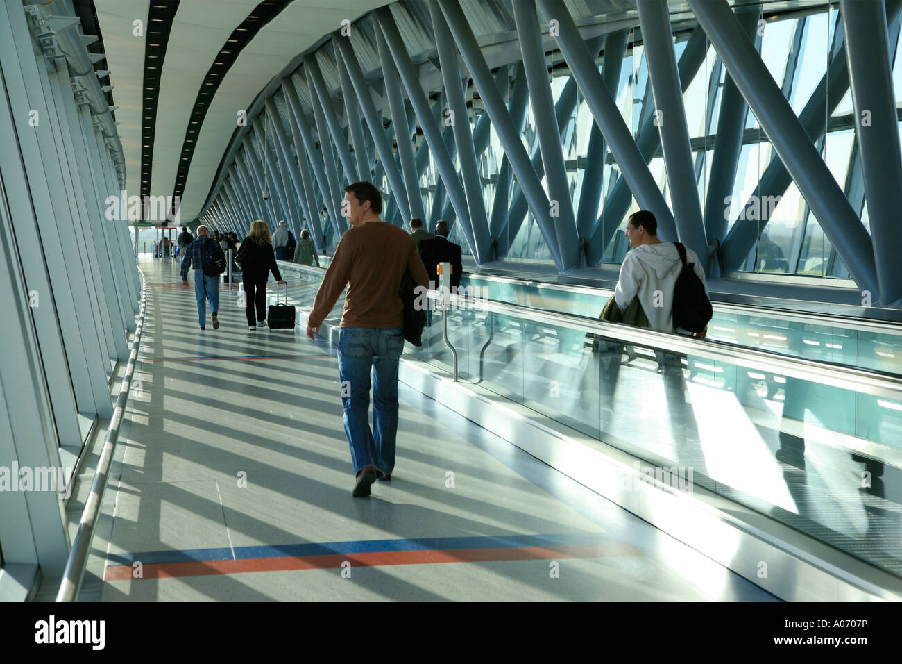 Passengers walking acccross new passenger walkway bridge to aircraft ...