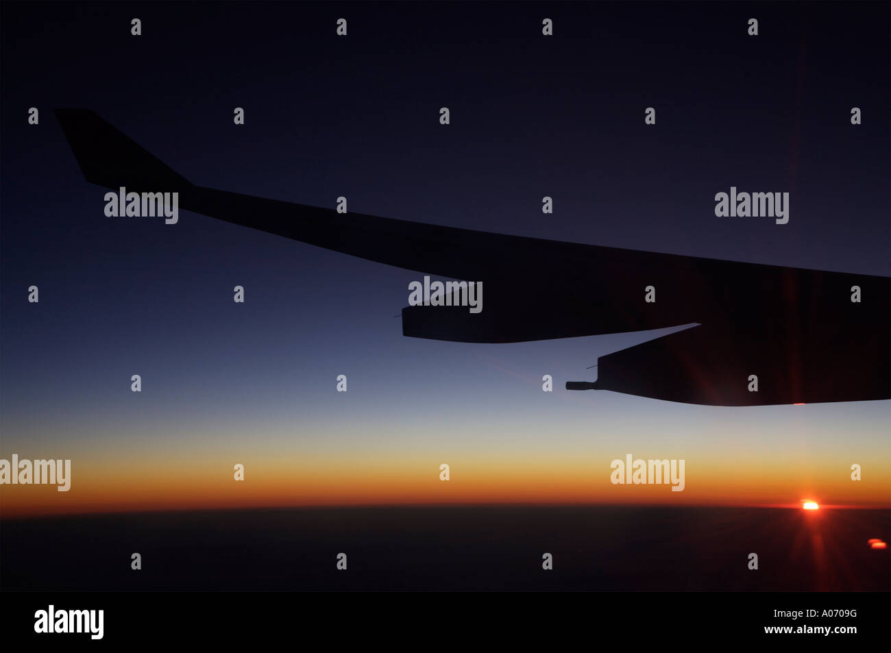 dramatic sunset and dusk as seen from an airplane window over the ...