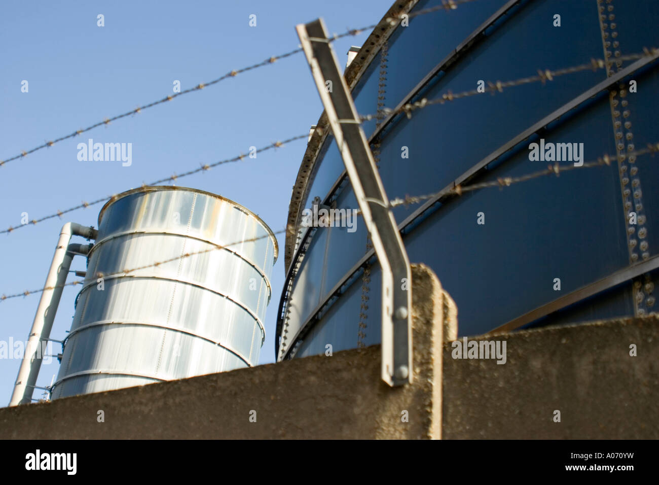 steel tanks of factory works, behind high rise barbed wire security ...