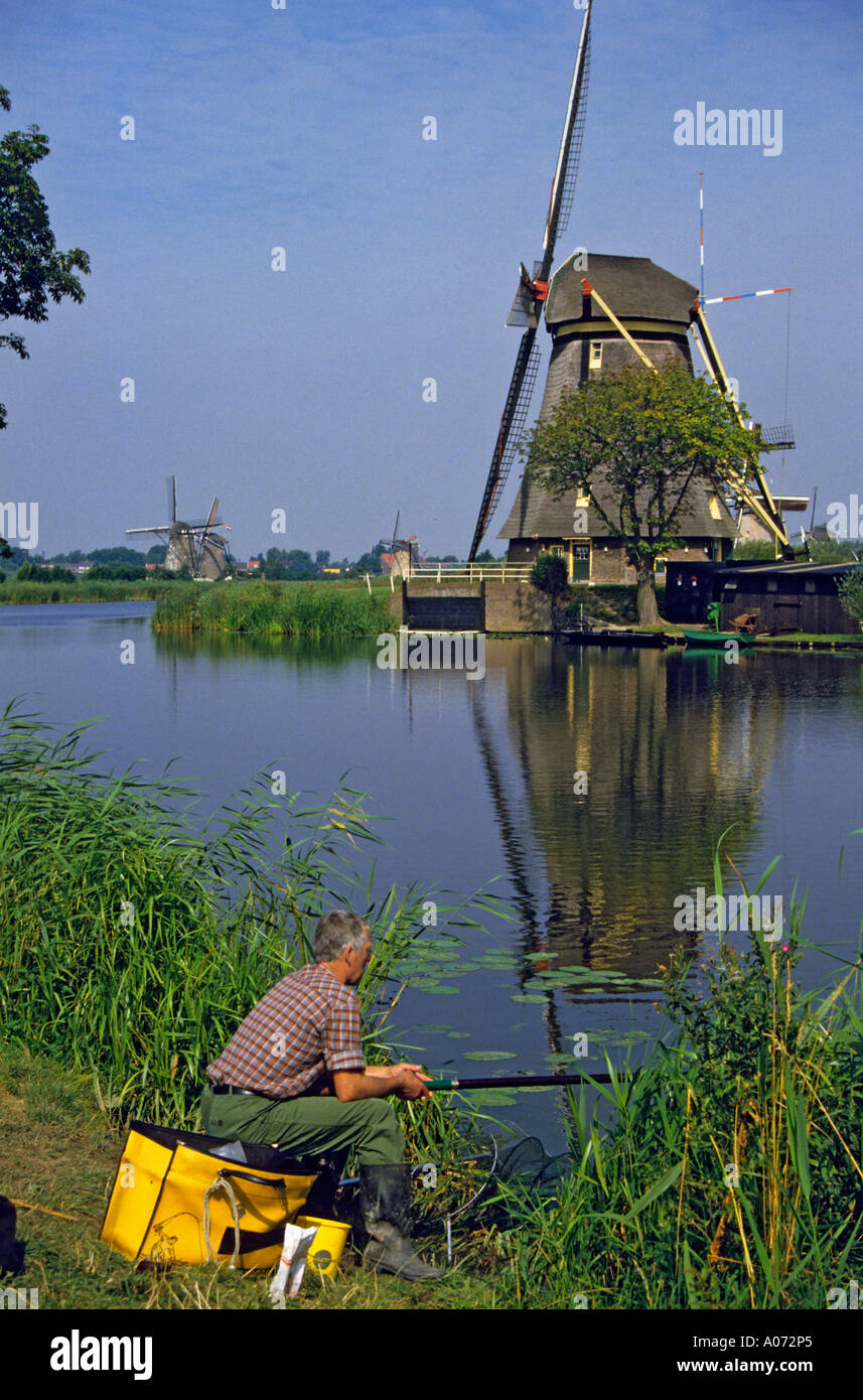 Fisherman at canal with windmill Holland Netherlands Europe Stock Photo ...