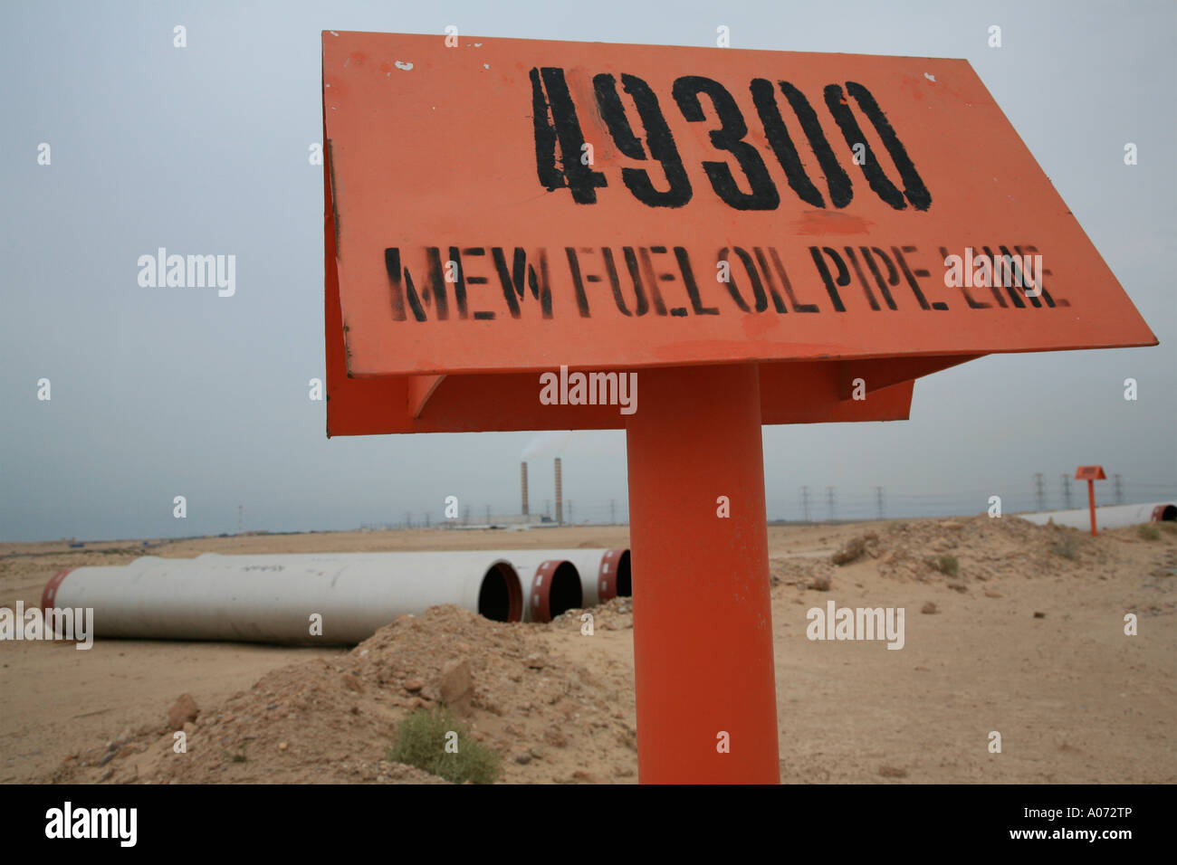 signage by industrial oil pipes ready to put in ground and connected ...