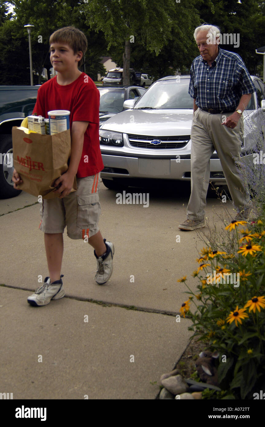 5th Grade Boy Helps Older Man Bring Groceries From Car Stock Photo - Alamy