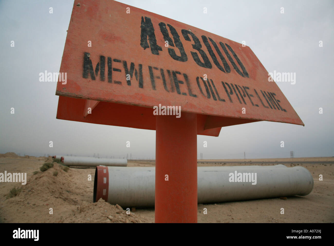 signage by industrial oil pipes ready to put in ground and connected ...