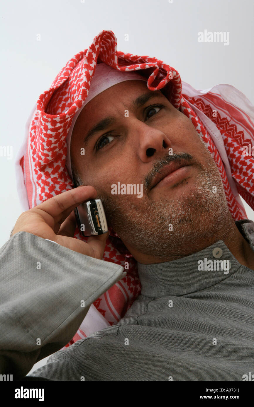 arab man on mobile phone wearing dish dash headwear in kuwait middle ...