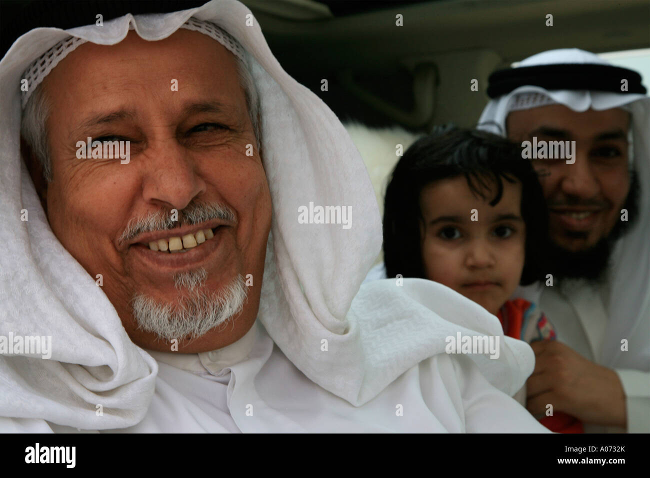 smiling family of arabs in their desert going vehicle in kuwait middle ...