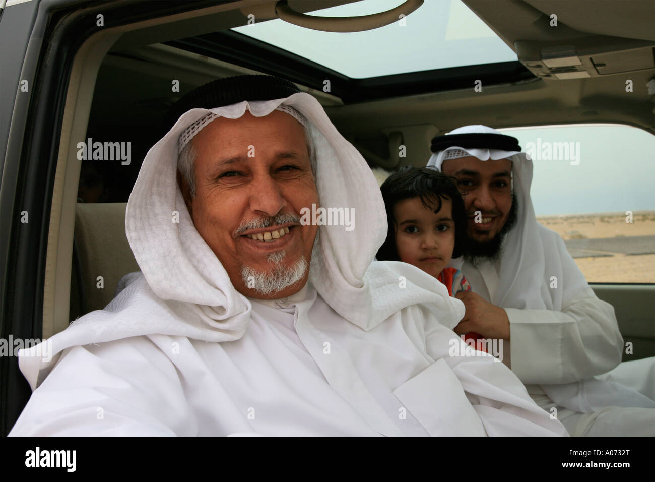 smiling family of arabs in their desert going vehicle in kuwait middle ...