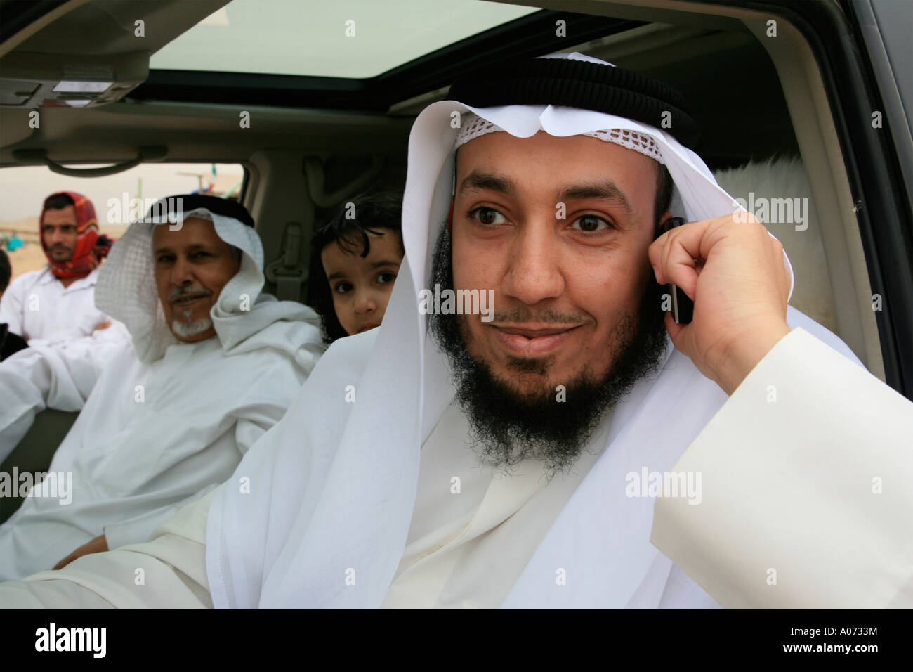 smiling family of arabs in their desert going vehicle in kuwait middle ...