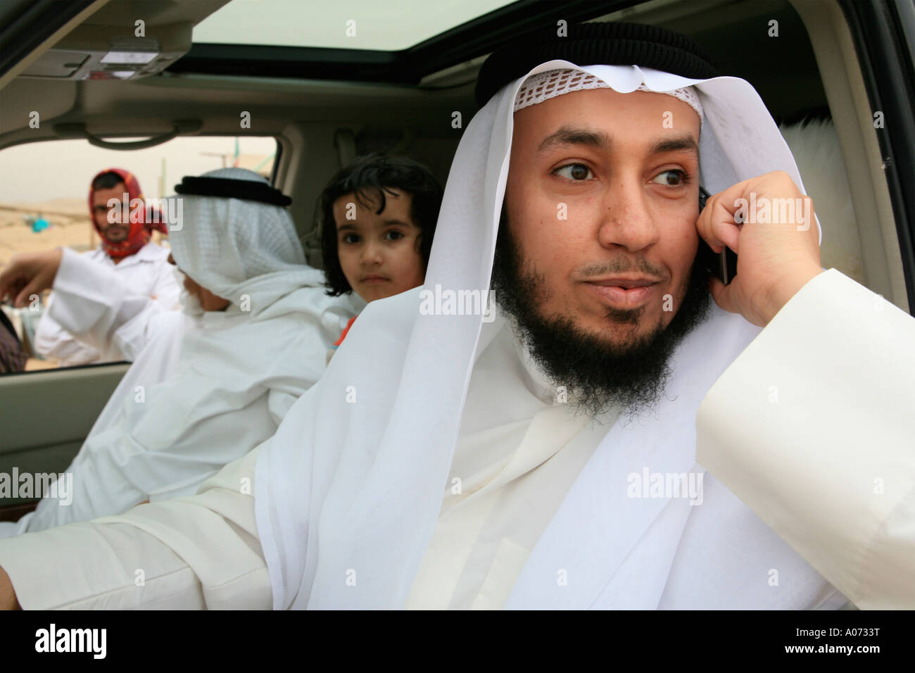 smiling family of arabs in their desert going vehicle in kuwait middle ...