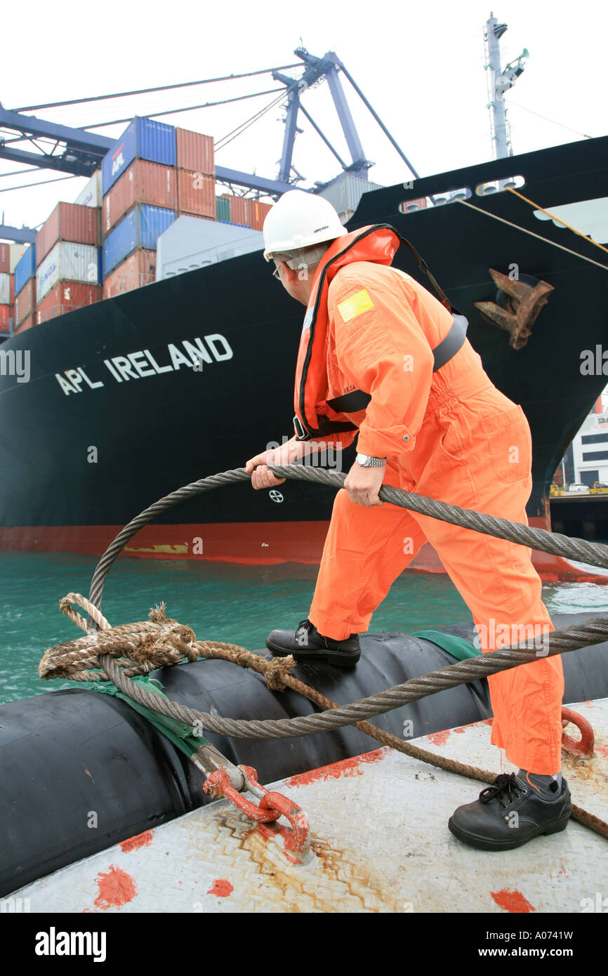 Tugboat sailor ready with mooring rope while manoevering in Kwai Chung ...