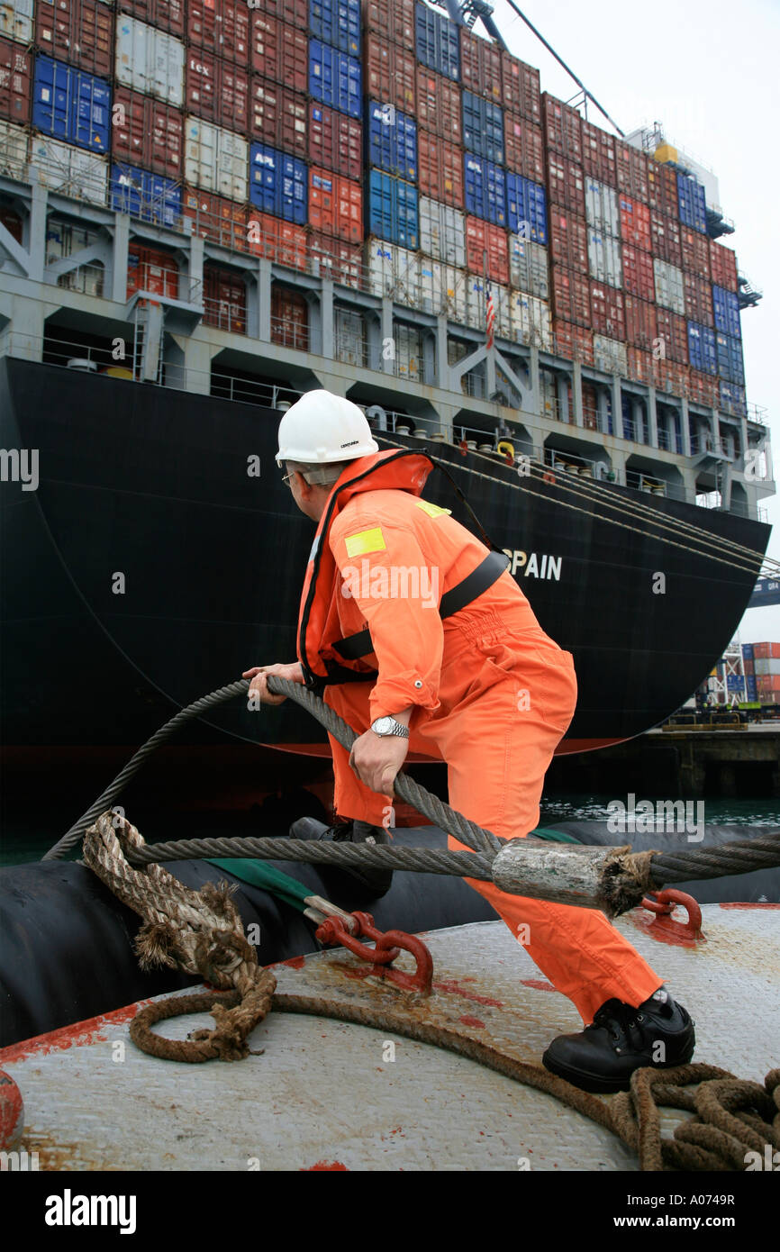 Tugboat sailor ready with mooring rope while manoevering in Kwai Chung ...