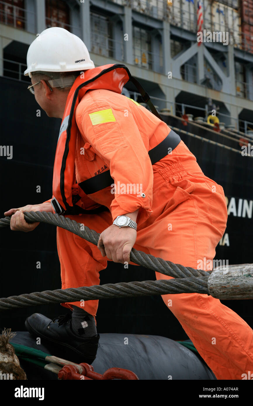 Tugboat sailor ready with mooring rope while manoevering in Kwai Chung ...