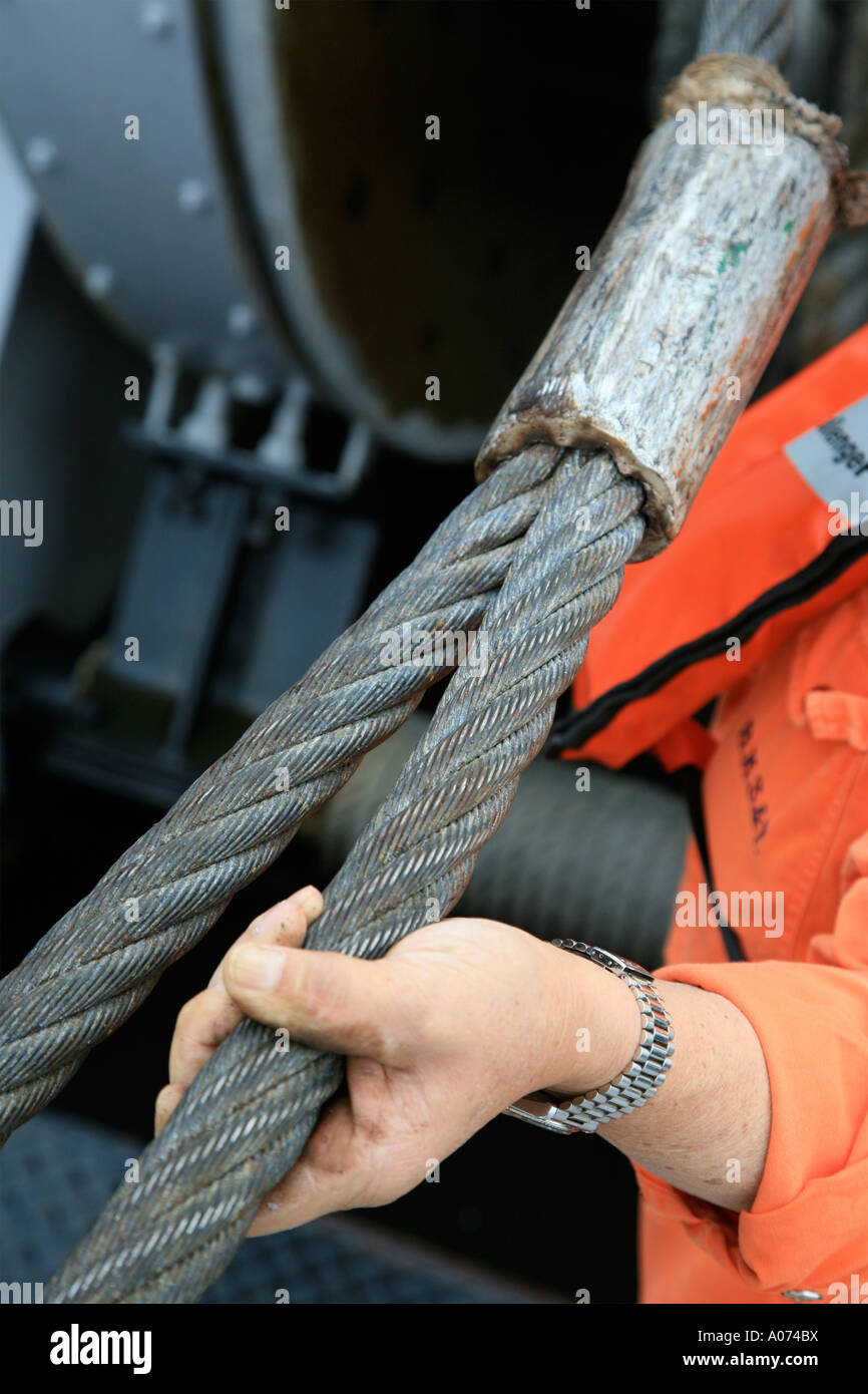 graphic shot of Tugboat sailor ready and pulling mooring rope seen ...