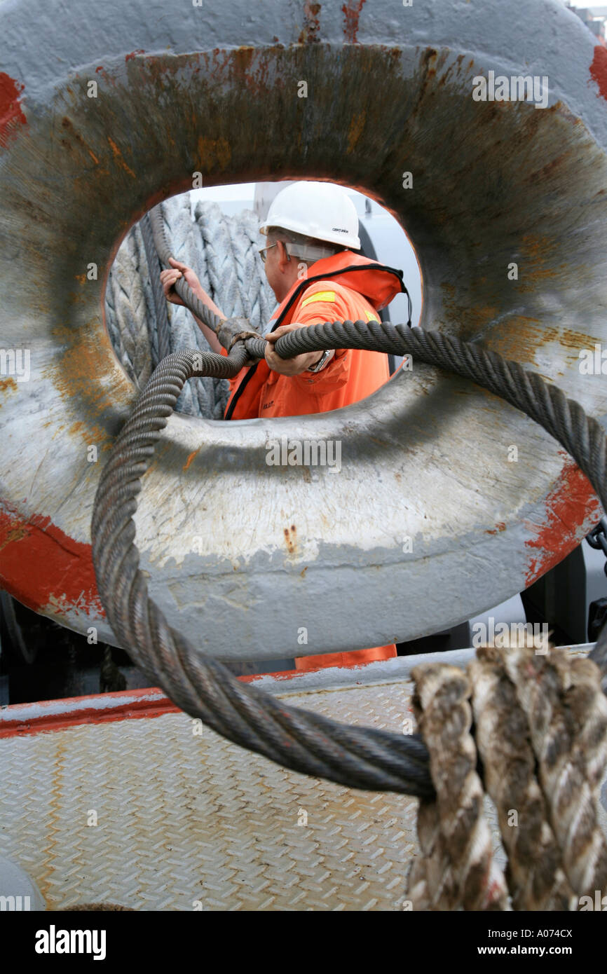 graphic shot of Tugboat sailor ready and pulling mooring rope seen ...