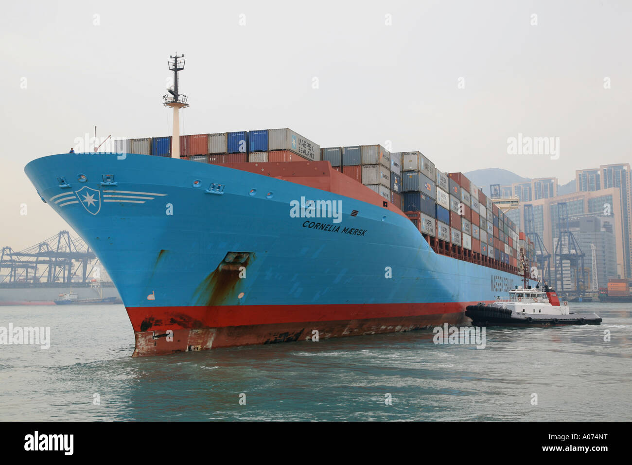 Tugboats manoevering around an ocean going containership at kwai chung ...