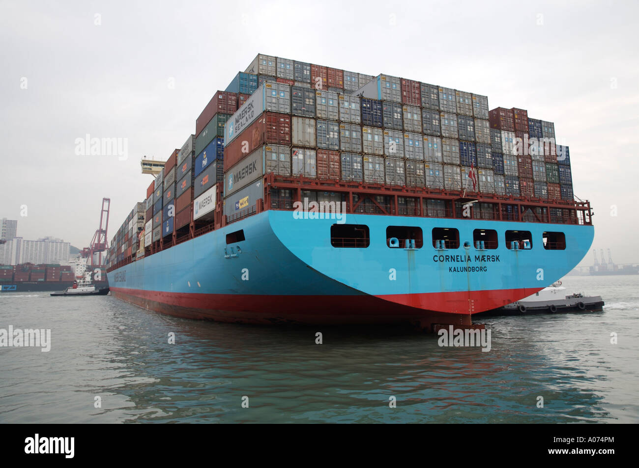 Tugboats manoevering around an ocean going containership at kwai chung ...