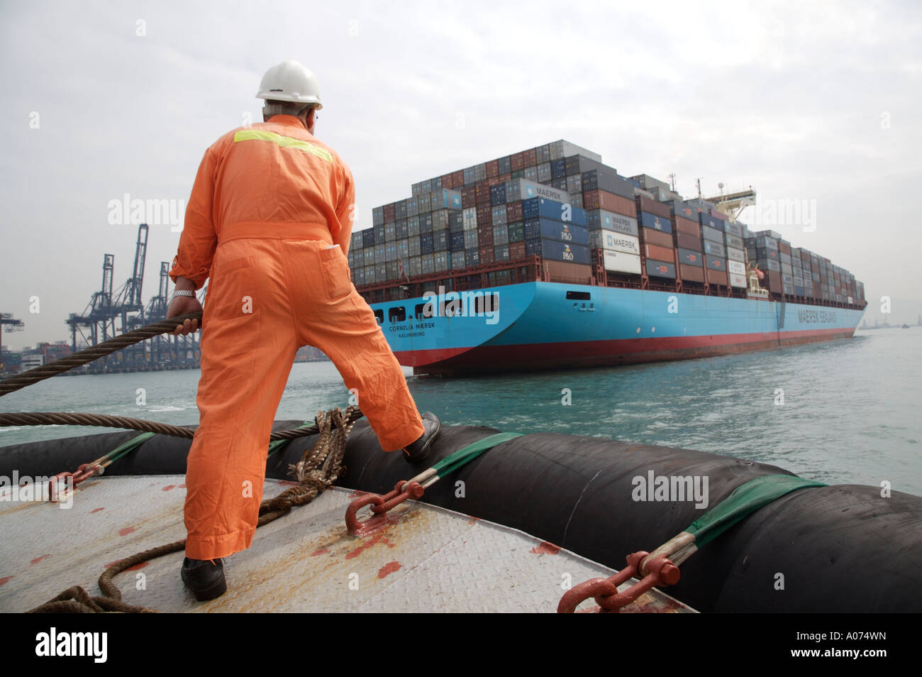 Tugboat sailor ready with mooring rope while manoevering in Kwai Chung ...
