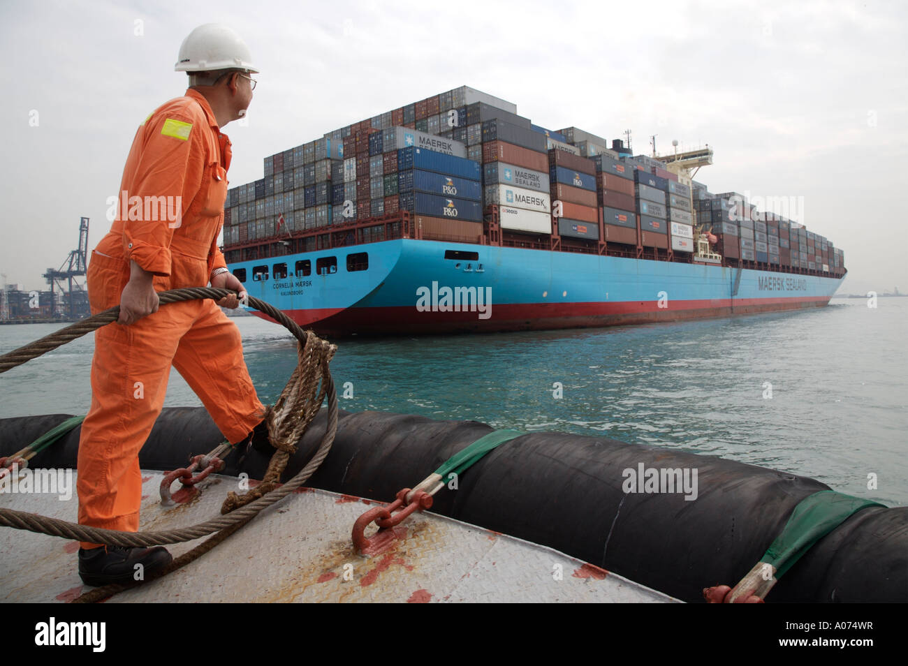 Tugboat sailor ready with mooring rope while manoevering in Kwai Chung ...