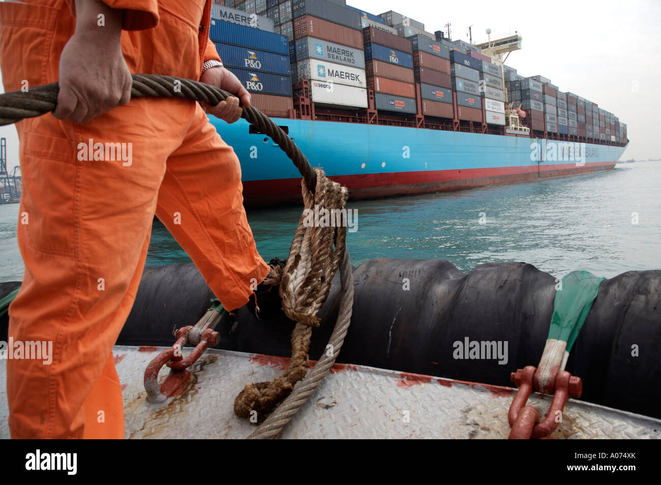 Tugboat sailor ready with mooring rope while manoevering in Kwai Chung ...