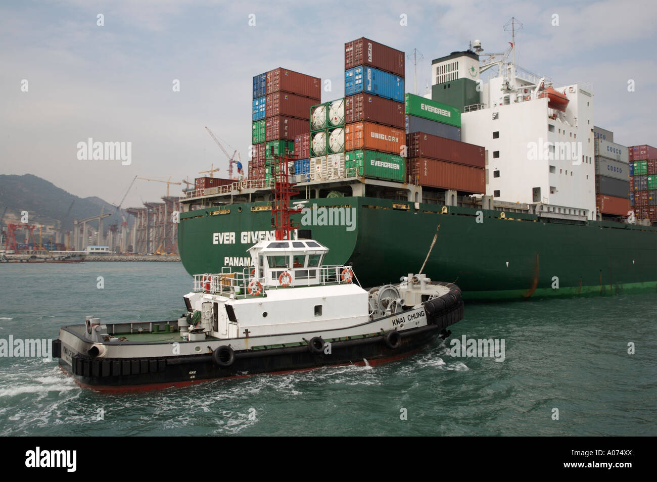 Tugboats manoevering around an ocean going containership at kwai chung ...