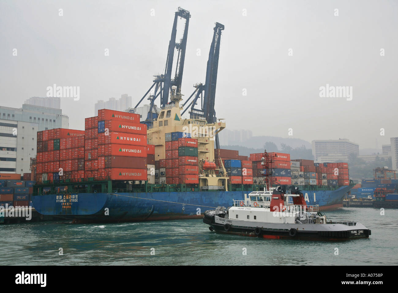 Tugboat manoevering in Kwai Chung by a container ship in Container Port ...