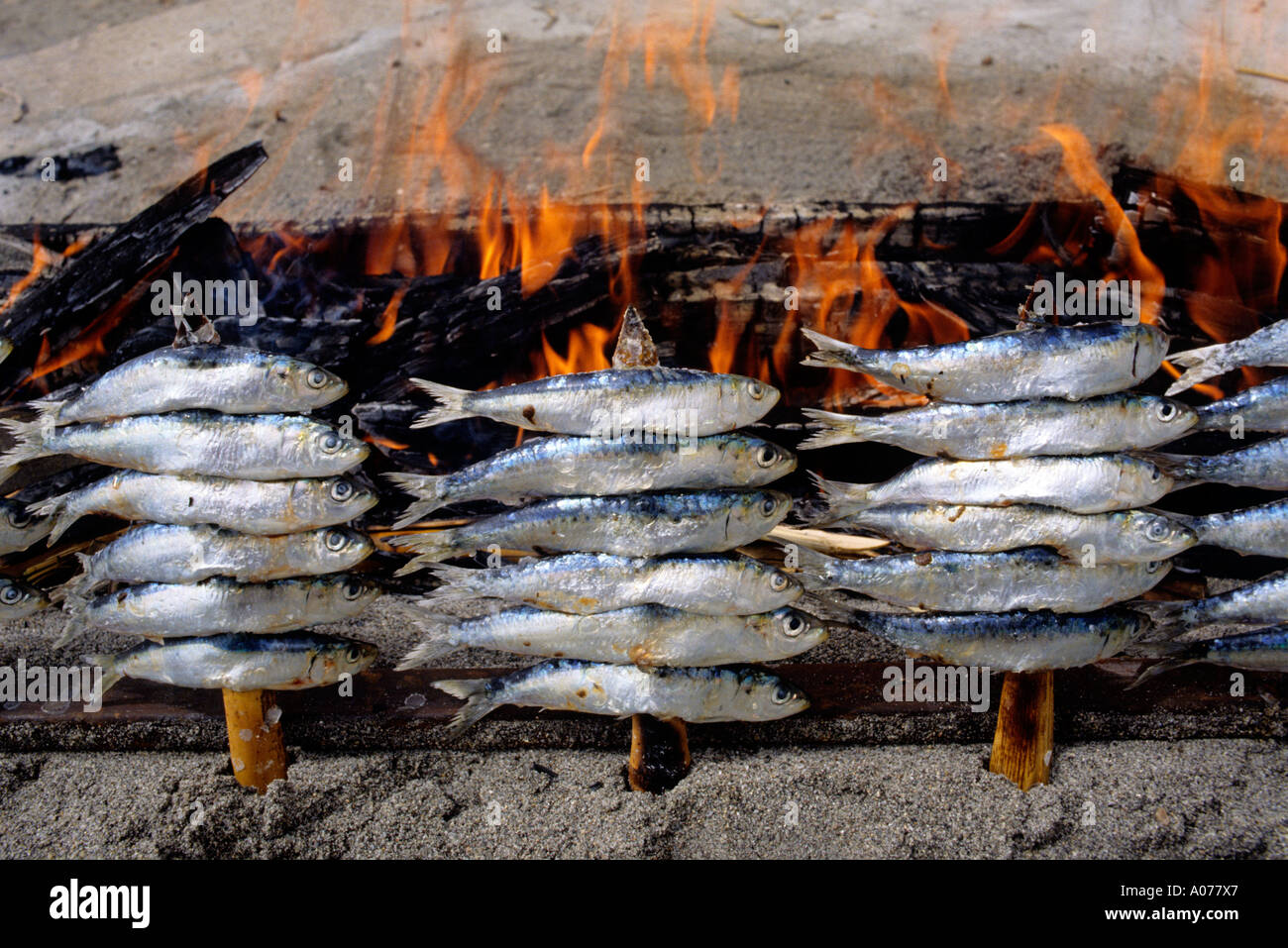 Smoking sardines near an open fire in Nerja, Spain Stock Photo - Alamy