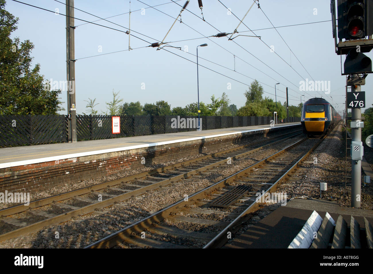 High speed train on East Coast main line passing through a rail station ...