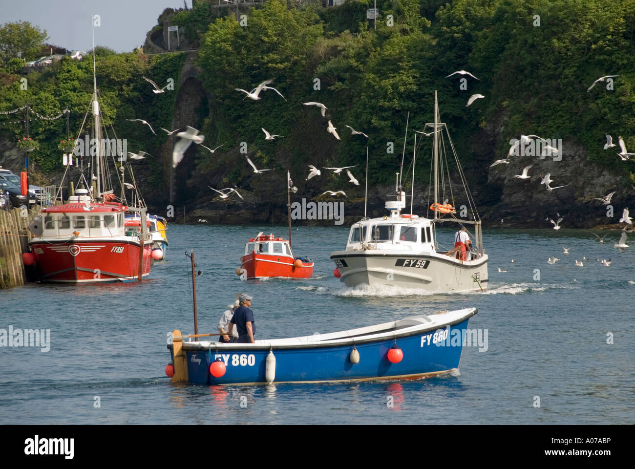 Small ferry crossing from East to West Looe with fishing boat returning ...