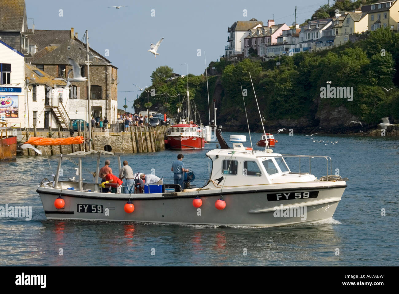 River Looe and men on fishing boat preparing to unload fish catch as ...