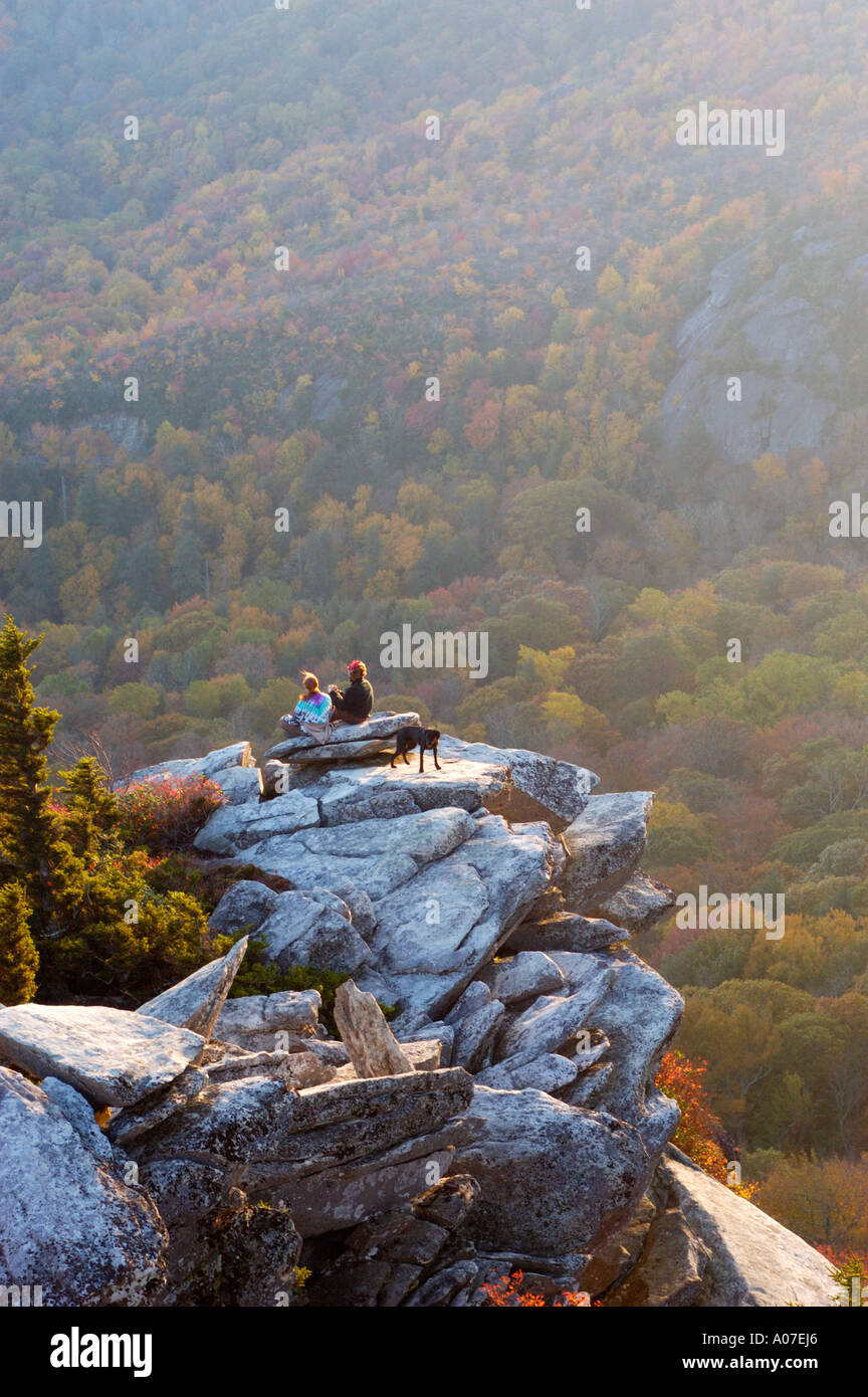 Two hikers and dog on rocky cliff in Appalachian Mountains with fall ...