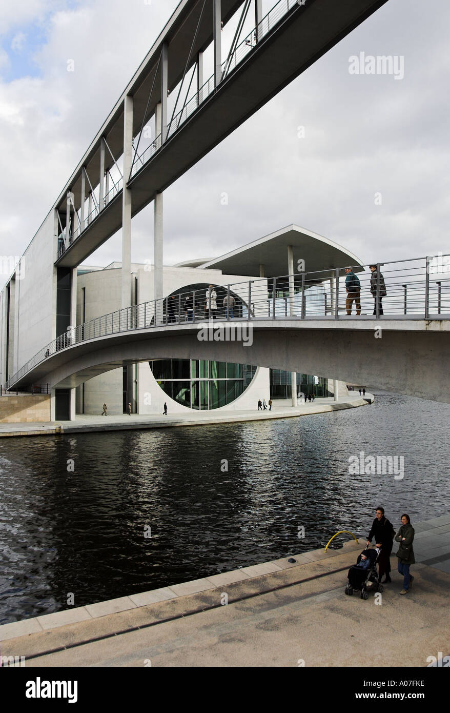 People walk around the new buildings alongside the Spree, and the ...