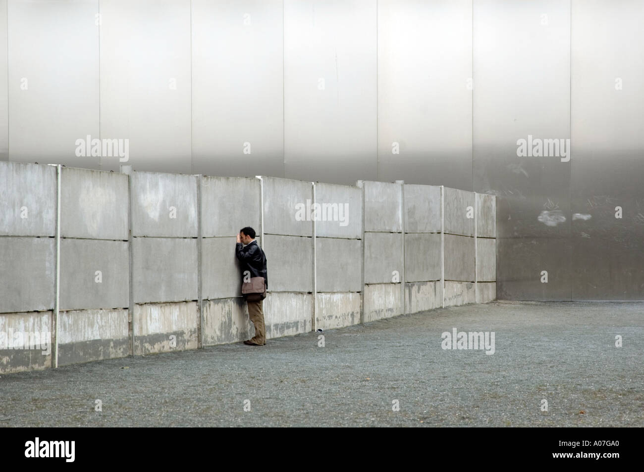 PERSON LOOKING THROUGH SLIT IN WALL AT THE BERLIN WALL MEMORIAL GERMANY ...
